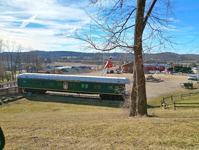 The vintage train car's emerald green contrasts beautifully with the bobblehead's red jacket. Two different eras of Americana sharing one unique space.
