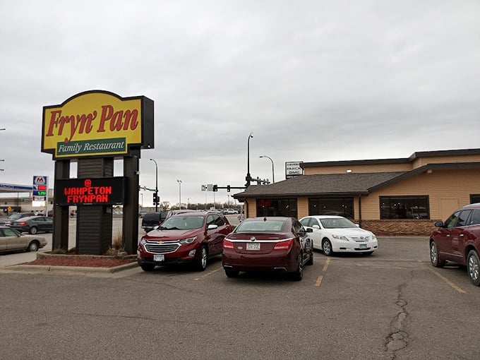 The Fryn' Pan Family Restaurant sign glows like a beacon for hungry travelers seeking comfort food that hasn't changed recipes since your parents' first date.