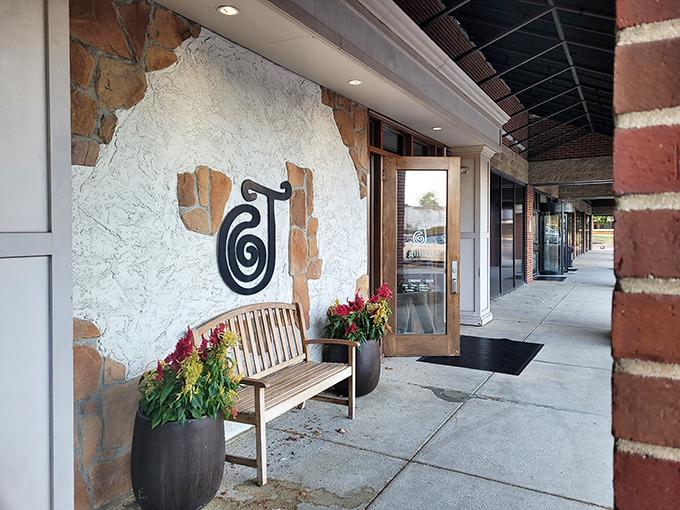 The entrance welcomes you with understated elegance, a wooden bench inviting you to pause before the flavor journey begins.