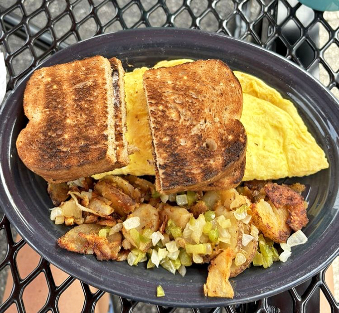 Western omelet with enough filling to require structural engineering, served on a plate that barely contains it.
