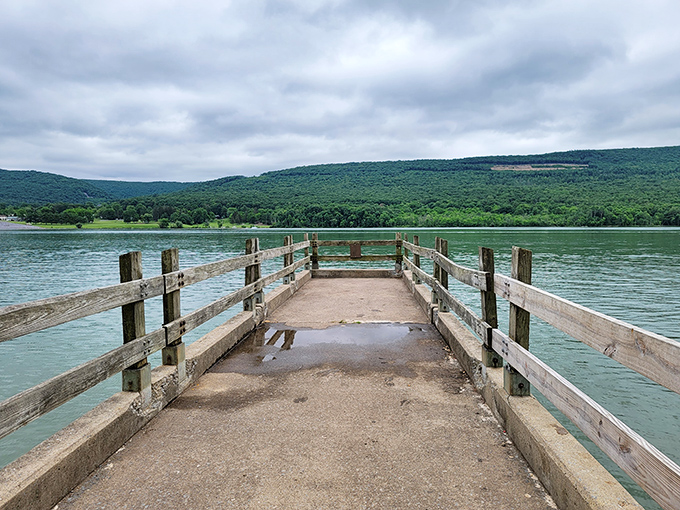 This weathered dock invites contemplation as it reaches toward the distant shore. Some paths lead to destinations; this one leads to tranquility.
