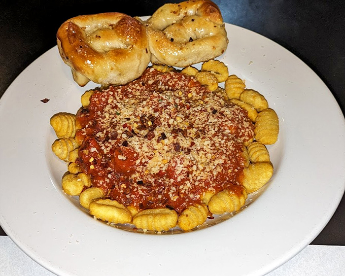 Gnocchi Bolognese surrounded by garlic rolls&mdash;a plate that says "you won't need dinner tomorrow" in the most delicious way possible.