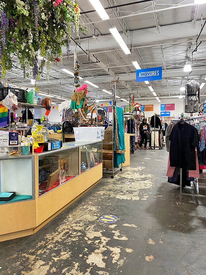 Artificial flowers hang from the ceiling like an upside-down garden, while unicorn heads stand guard over the accessories section.