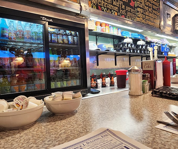 The counter view&mdash;where regulars perch and newcomers become converts. Classic diner condiments stand ready for their supporting roles.