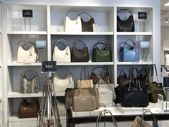 Handbags arranged with gallery-like precision, each one a potential new companion for your wallet and keys at a fraction of department store prices.