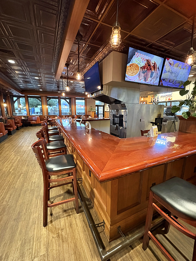 The bar area gleams with warm wood tones and pendant lighting, creating the perfect perch for solo diners or happy hour enthusiasts.