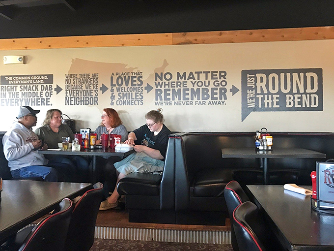 Booth seating adorned with the restaurant's philosophy spelled out on the wall. "No matter where you go, remember we're never far away."