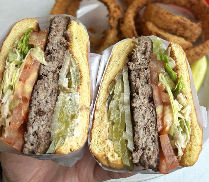 This isn't just a burger; it's an architectural marvel of beef, vegetables, and condiments that requires both hands and possibly a building permit.