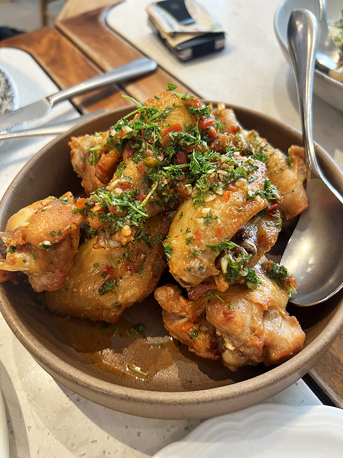 These aren't just chicken wings—they're flavor grenades, glistening with sauce and herbs that make you reconsider everything you thought you knew about this humble appendage.