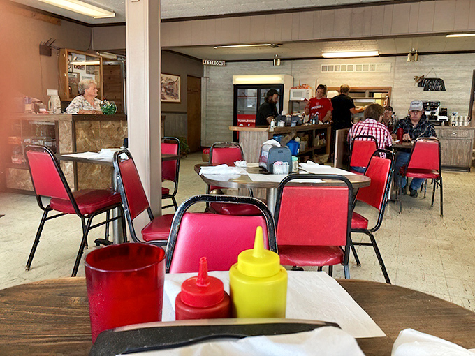 Red chairs pop against neutral walls in this section of the caf&eacute;. The condiment trio stands ready for whatever deliciousness arrives next. 