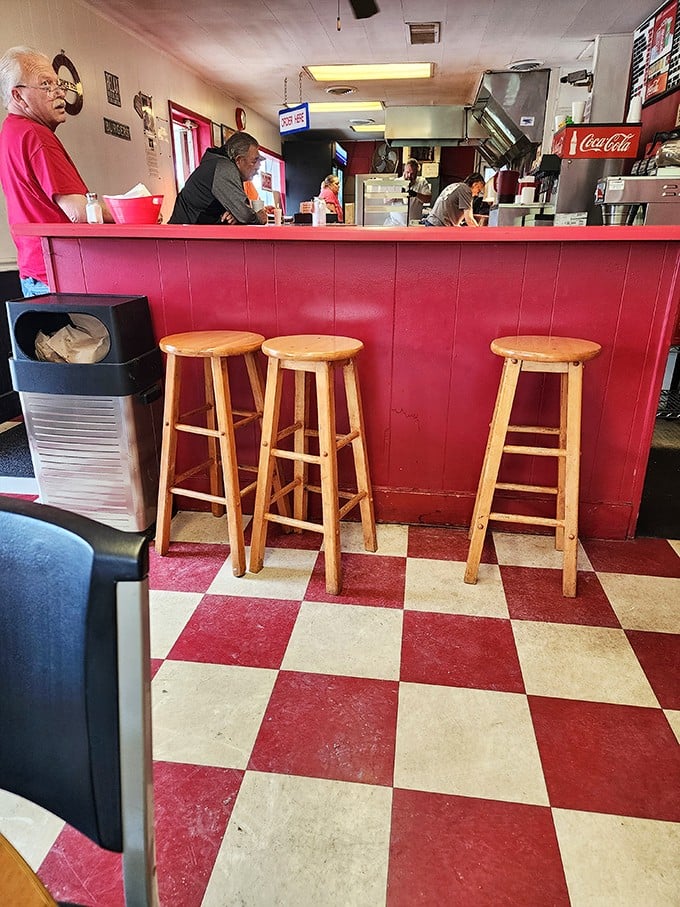Three empty stools await their next hungry patrons. The red counter has supported the elbows of generations of Bloomington burger enthusiasts.