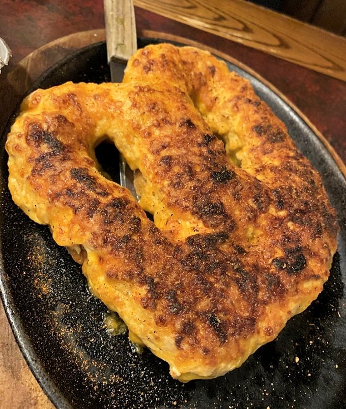 This pretzel looks like it's wearing a cheesy crown, ruling over the kingdom of bar snacks with benevolent, golden-brown authority.