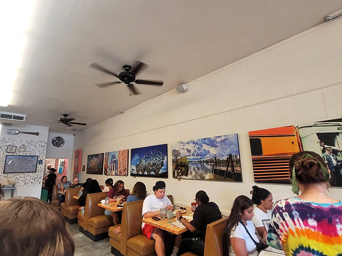 The dining room hums with satisfied customers, local artwork lines the walls, and breakfast dreams come true under gently spinning ceiling fans.