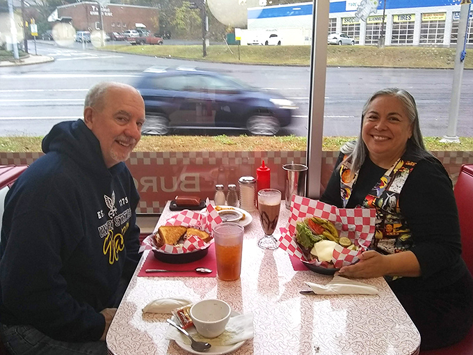 Happy diners sharing a meal by the window&mdash;the universal language of good food bringing smiles that no five-star restaurant could improve upon.