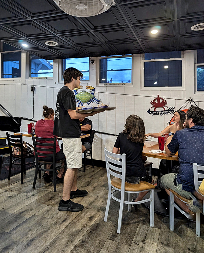 The server carries blue crabs like Olympic torches to eager diners—a ceremonial procession that ends in delicious demolition.