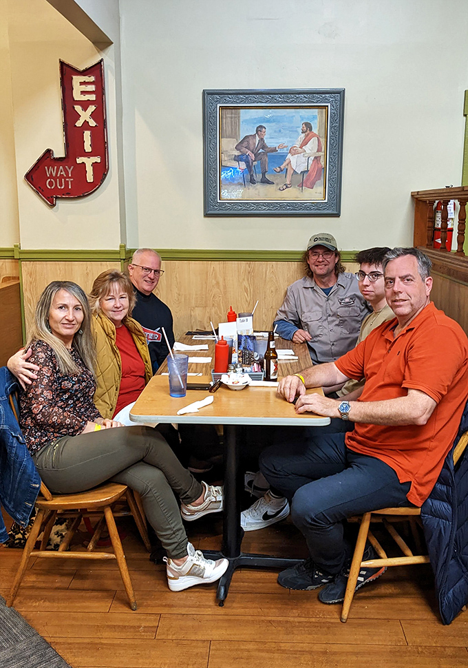 Happy diners gathered around a table prove that the best restaurants are really just community gathering spots with exceptional food.