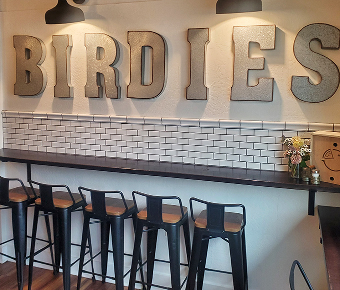 Metal letters spell out BIRDIE'S against white subway tile—a modern backdrop for timeless treats. The industrial-chic counter seating invites solo pie enthusiasts.