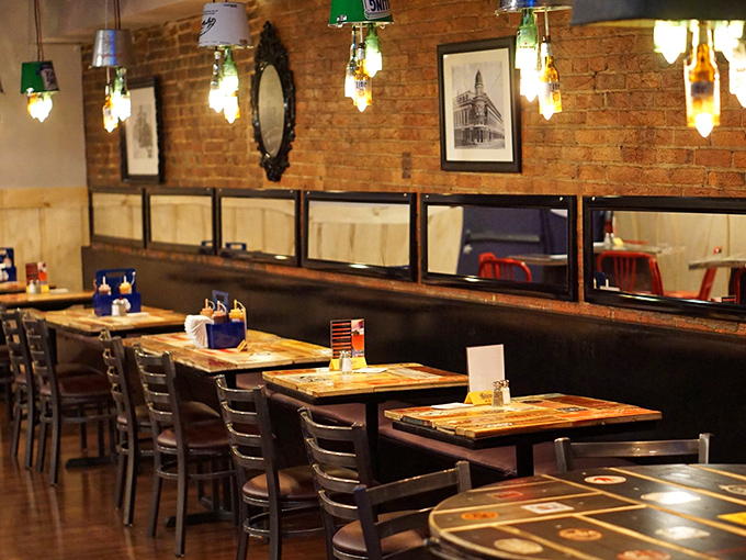 The dining area's exposed brick and bottle-lamp lighting create that perfect Instagram-worthy backdrop that somehow still feels authentically unpretentious.