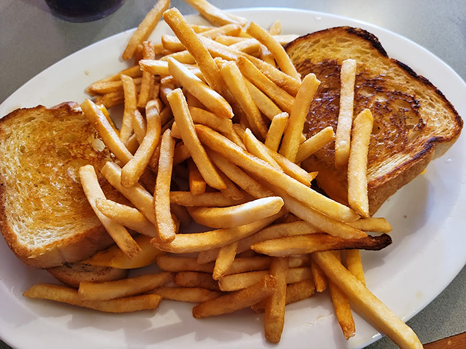 Golden fries piled high beside Texas toast – because sometimes you need carbs with your carbs, no judgment.