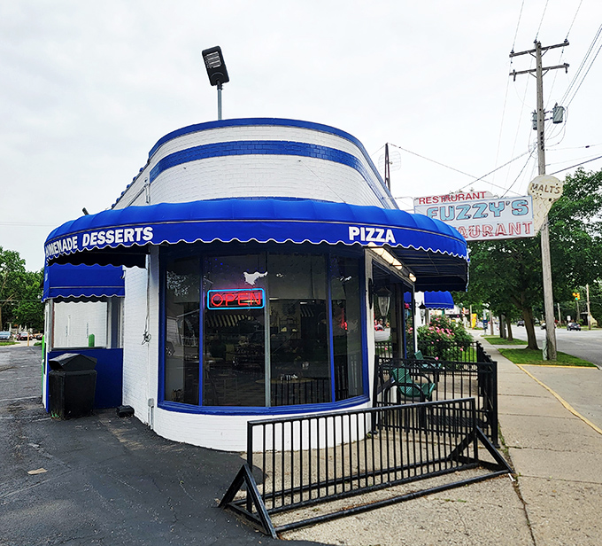 This distinctive rounded corner building stands like a beacon for hungry souls seeking authentic diner fare without the pretense.