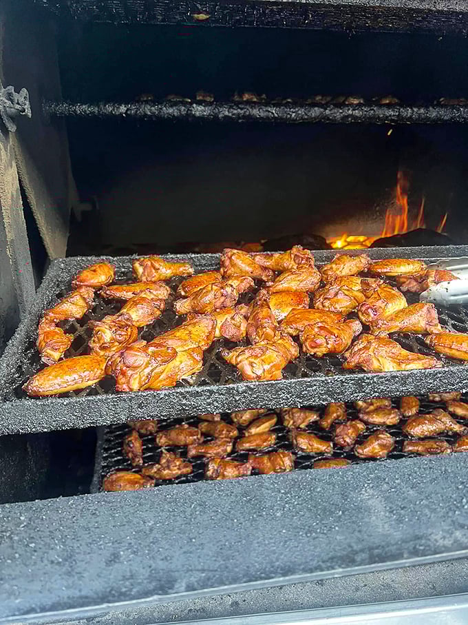 Where the magic happens – chicken wings getting their smoky baptism over open flames in a scene that would make a vegetarian reconsider.