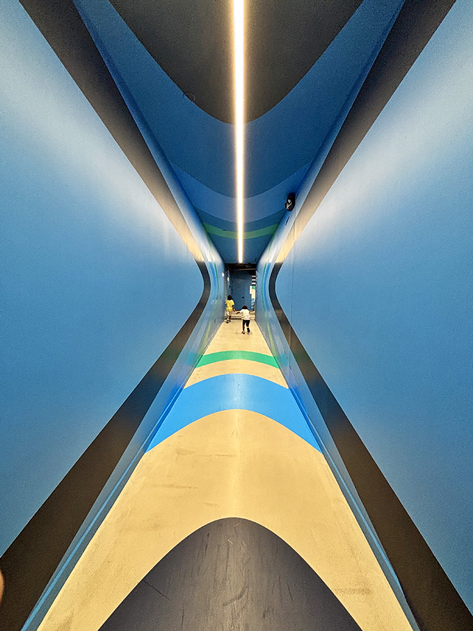 This perspective-warping hallway creates the sensation of walking through an hourglass&mdash;time and space bending with each step forward. 