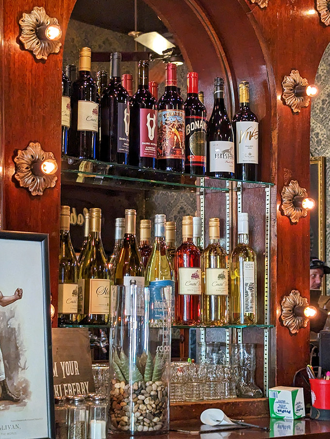 The wine selection stands ready like well-dressed guests at a party. Each bottle waiting for its moment to complement a perfectly grilled steak.