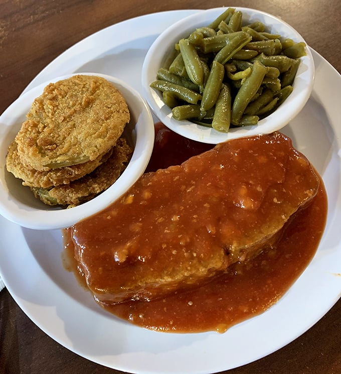 Meatloaf swimming in tomato gravy with a side of green beans and fried green tomatoes. The holy trinity of Southern comfort.
