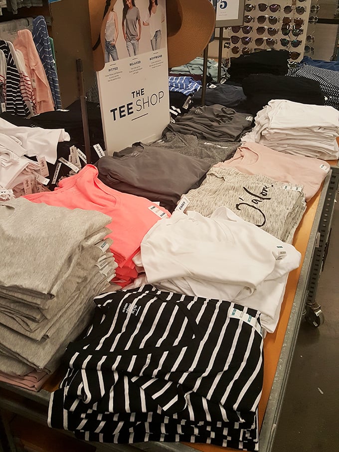 Neatly folded t-shirts await shoppers looking to refresh their casual wardrobe. The universal shopping truth: you came for one black t-shirt but left with six colors.