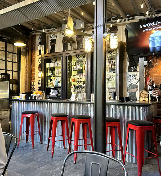 The industrial-meets-rustic aesthetic continues at this secondary bar, where red stools pop against corrugated metal and exposed brick.
