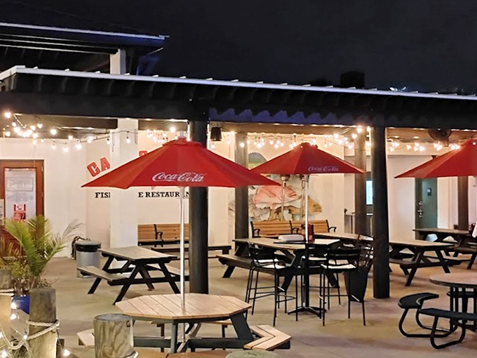 The outdoor dining area where evening meals become magical under string lights. Red umbrellas and picnic tables invite you to linger just a little longer.