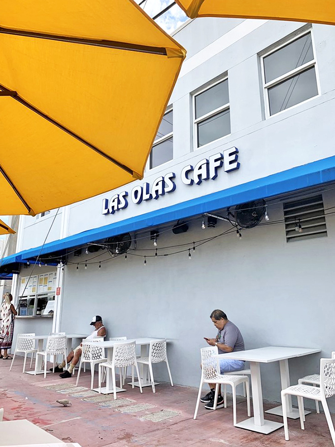 Yellow umbrellas provide shade for outdoor diners enjoying their Cuban coffee and sandwiches on Miami Beach's sunny sidewalks.
