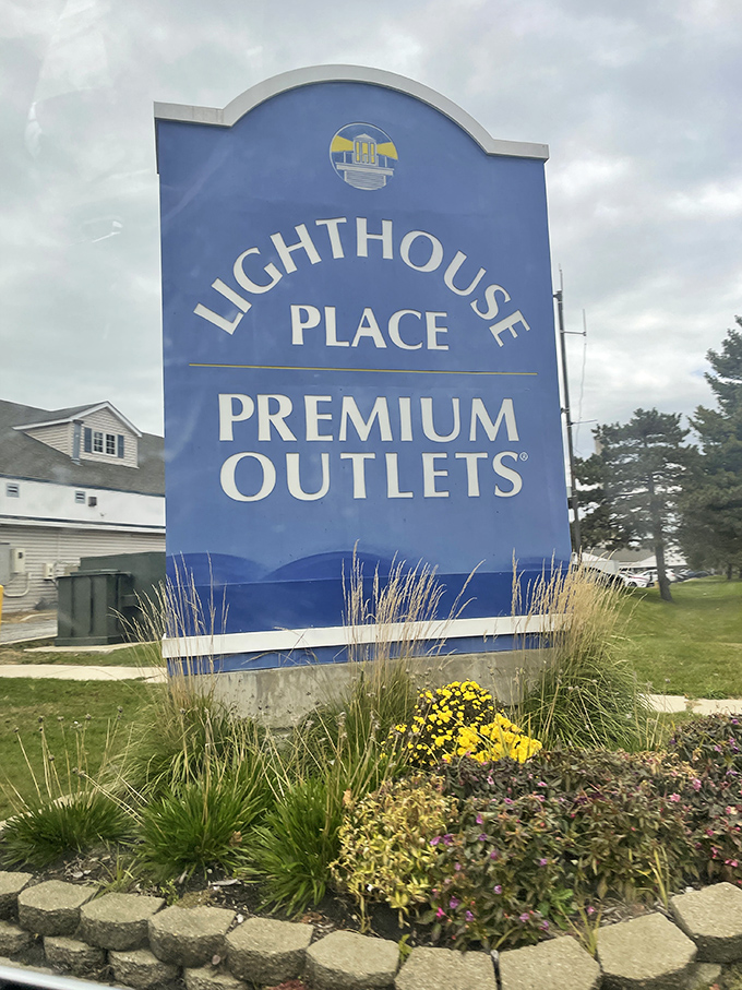 The official welcome sign, surrounded by carefully manicured landscaping. Your wallet's last chance to turn back before the temptation begins.