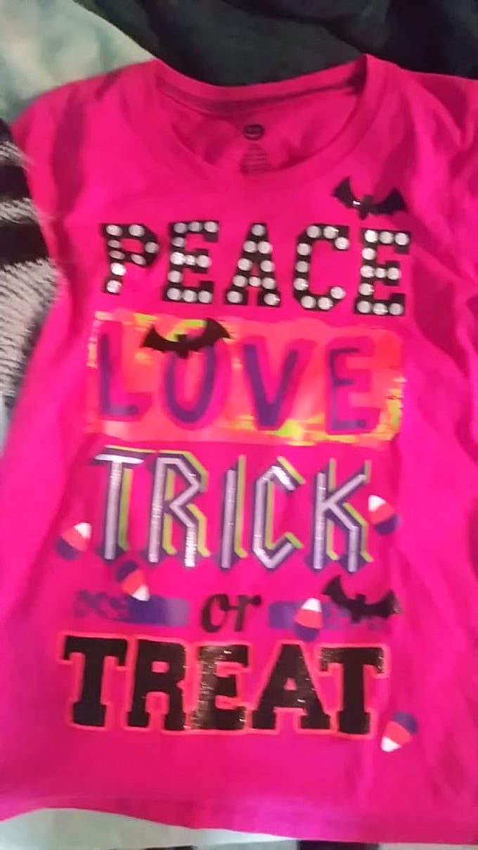 Halloween fashion that won't haunt your wallet&mdash;this "Peace Love Trick or Treat" shirt brings holiday spirit without the frightening price tag.