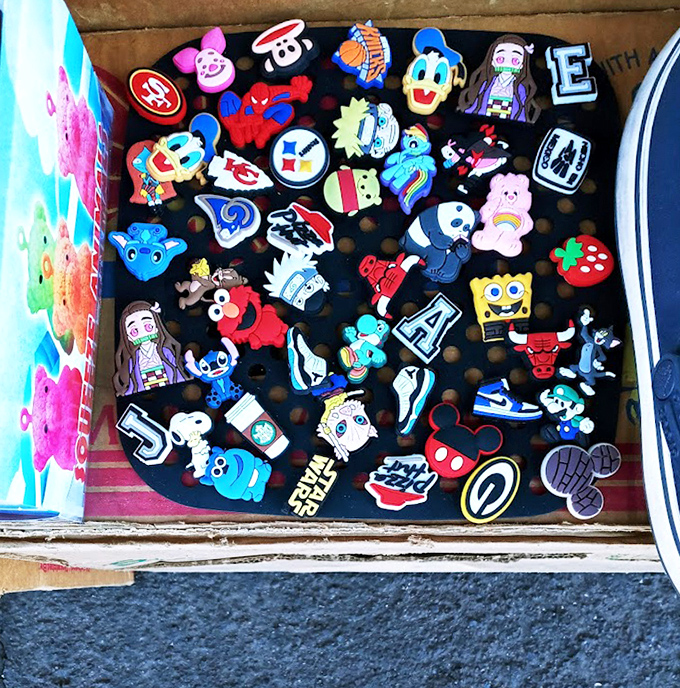 Tiny colorful pins create a mosaic of pop culture obsessions. Sports logos mingle with cartoon characters in this miniature gallery of personal expression.