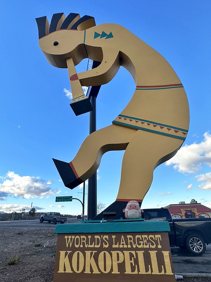 Even stuffed animals make pilgrimages to this roadside wonder. The plushie appears suitably impressed by its towering golden host.