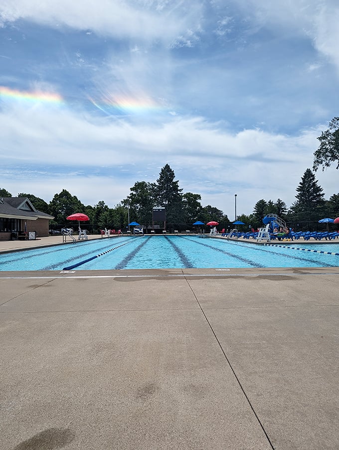 Midland's community pool shimmers under Michigan's summer sky, a blue oasis where rainbow umbrellas stand guard against the occasional sunburn.