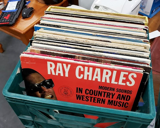 Vinyl treasures waiting for their encore. Ray Charles in a teal bin proves that legendary sounds never go out of style, just out of retail price range.