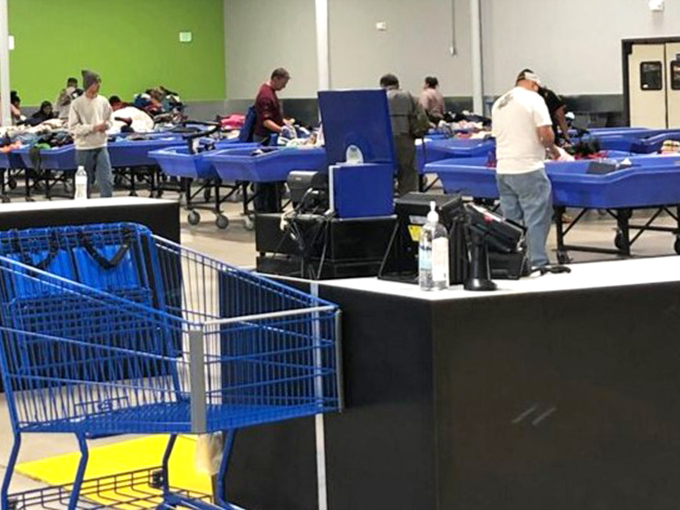 Serious thrifters in their natural habitat. Notice the methodical approach – these aren't amateurs but professionals who understand the rhythm of the bins.