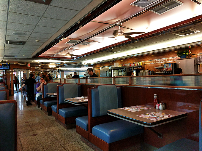 Classic diner seating arranged with mathematical precision &ndash; each booth a private island in a sea of comfort food possibilities.