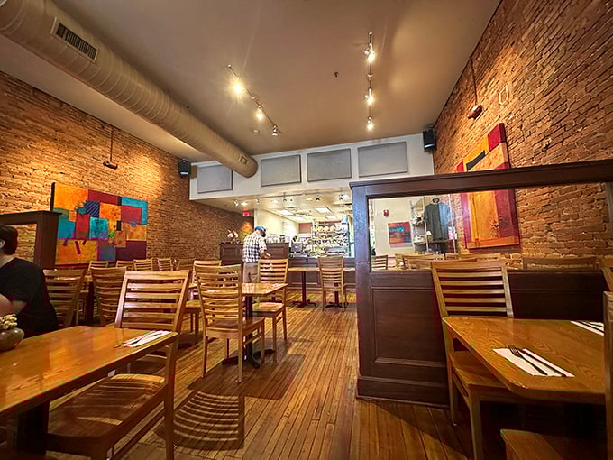 The dining room during a quiet moment—where exposed brick, wooden chairs, and track lighting create the perfect stage for culinary memories.