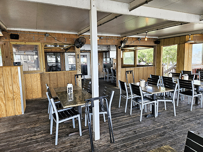 The weathered wooden deck seating offers that perfect blend of indoor comfort with the constant reminder that the water is just steps away. 