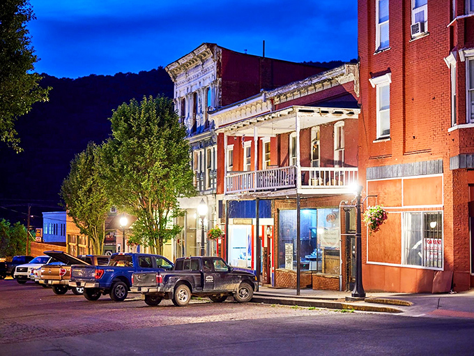 Evening transforms Hinton's storefronts into a twilight painting, where warm lights spill onto brick streets that have witnessed a century of stories.