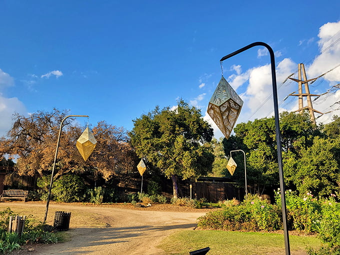 Artistic lanterns create whimsical trail markers throughout the gardens. Even practical elements become magical in this enchanted setting.
