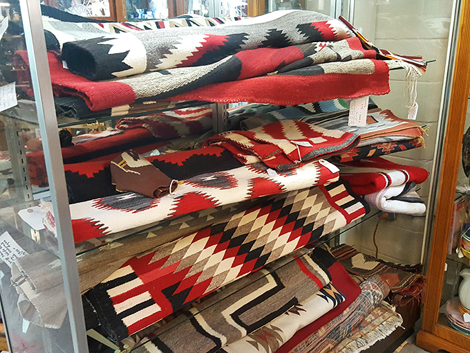 Navajo textiles stacked with care&mdash;each blanket a geometric symphony in wool, telling stories of tradition with every thread and pattern. 
