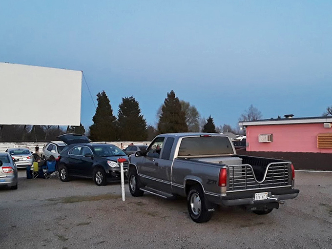 The pink glow of the concession stand rivals the screen for attention, proving that half the drive-in experience happens during the moments between scenes.