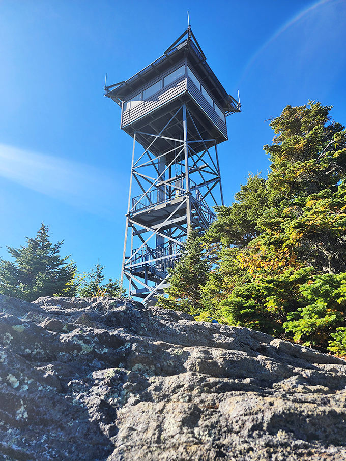 The fire tower stands like a sentinel from another era, offering views that no drone footage could ever truly capture&mdash;you simply have to earn them yourself.