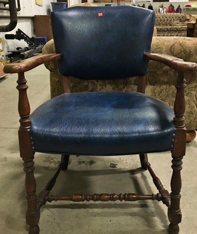 A navy blue vintage chair that whispers, "I've supported important bottoms before, and I'm ready to support yours too."