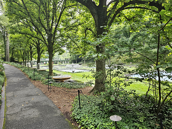 Shaded pathways offer glimpses of sunlit gardens beyond, creating that perfect tease that keeps you exploring "just a little bit further."