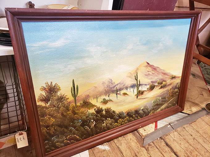 Desert landscape painting in warm hues that once graced a 1960s living room wall, now waiting for its renaissance in a modern space.